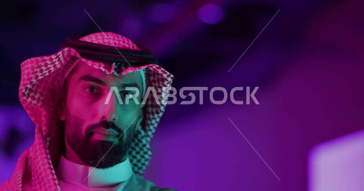 A Saudi Arabian Gulf man, taking a photo session with colored lighting ...