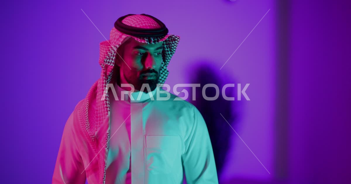A Saudi Arabian Gulf man, taking a photo session with colored lighting ...