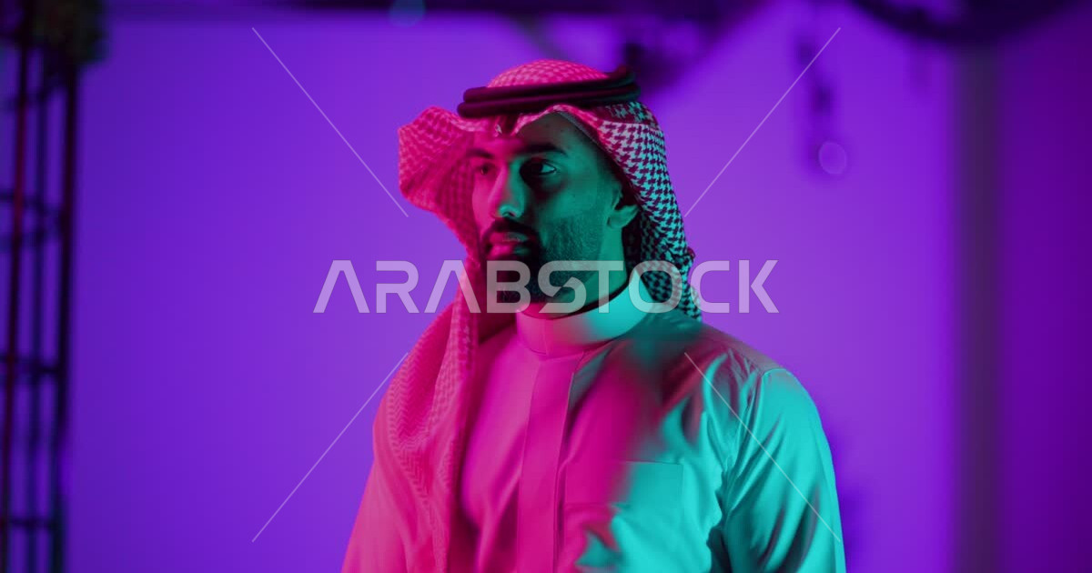 A Saudi Arabian Gulf man, taking a photo session with colored lighting ...