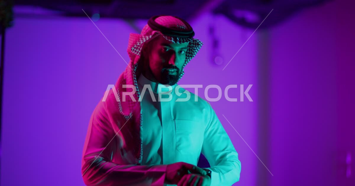 A Saudi Arabian Gulf man, taking a photo session with colored lighting ...