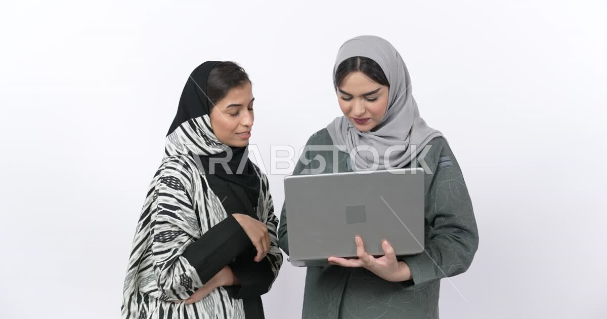 A Saudi Arabian Gulf business woman with a laptop in her hand, a Saudi ...