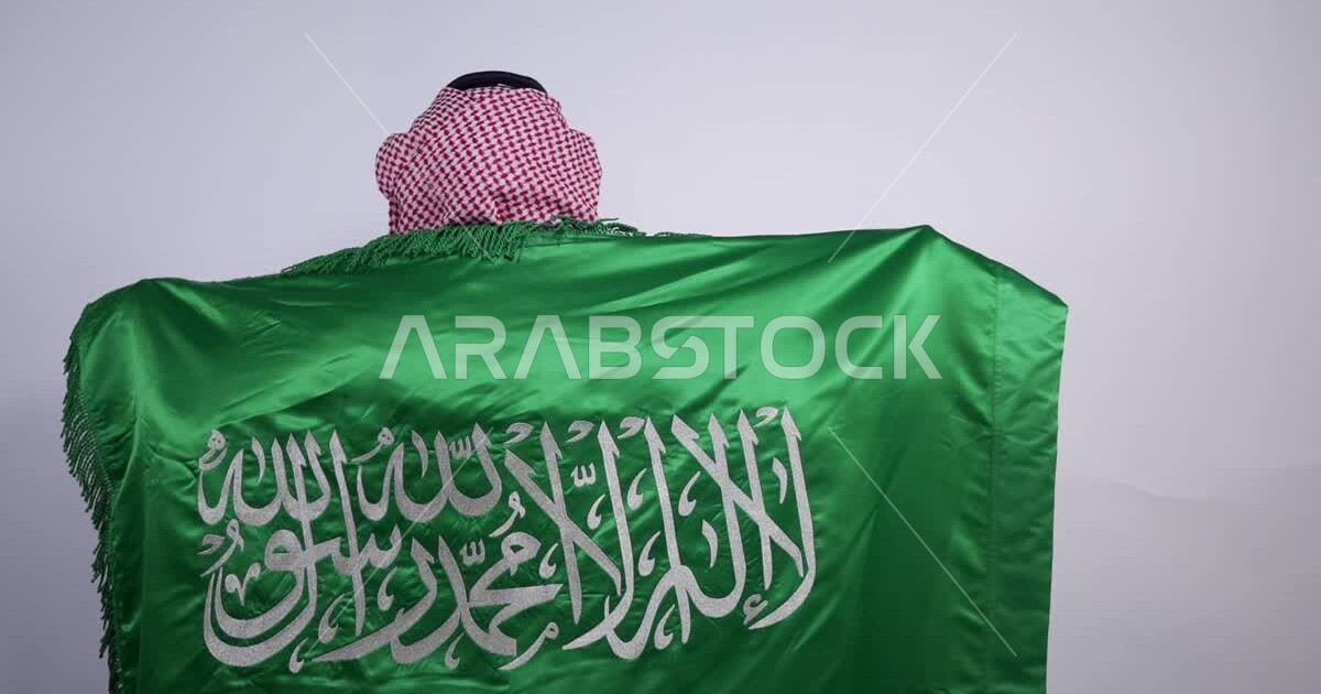 Portrait from the back of a Saudi Arabian Gulf man putting the flag of ...
