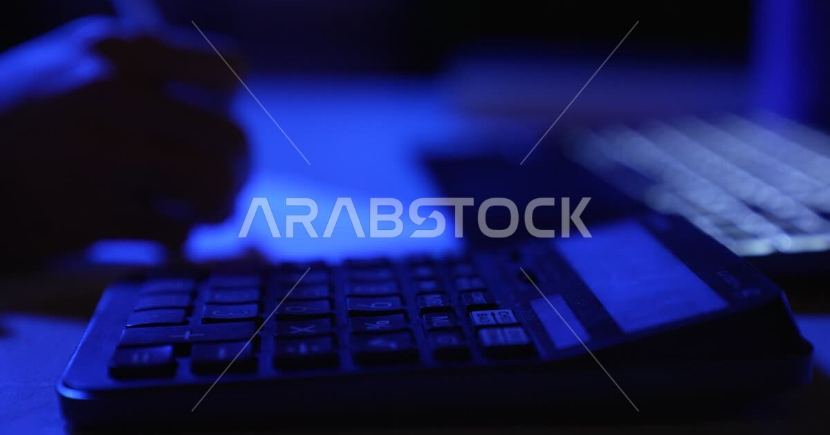 An Arab Gulf man using a calculator, an accountant working in the ...