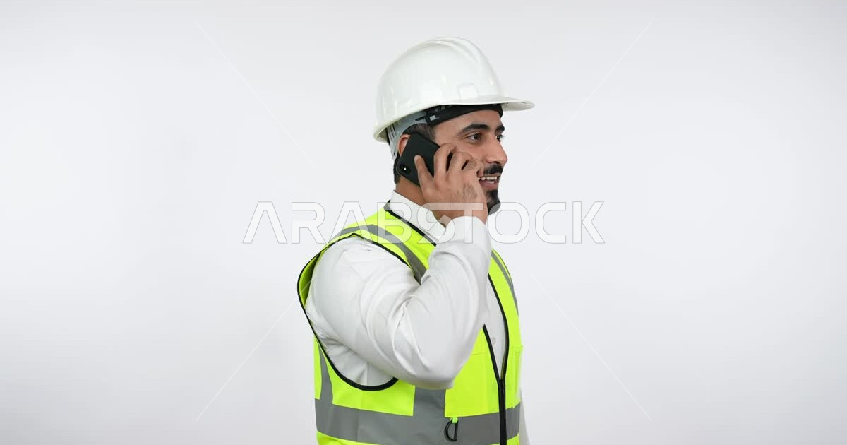 A Saudi Arabian Gulf engineer wearing a work helmet and jacket, making ...
