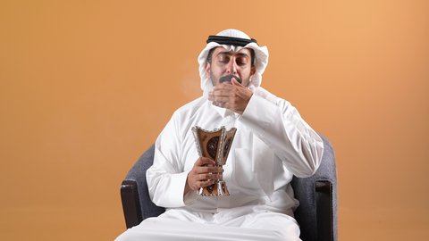 A portrait of a young Arab Gulf Saudi man wearing traditional attire ...