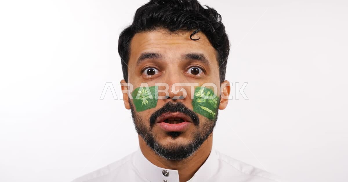 A Gulf Arab youth draws the Saudi flag on his face, encouraging the ...