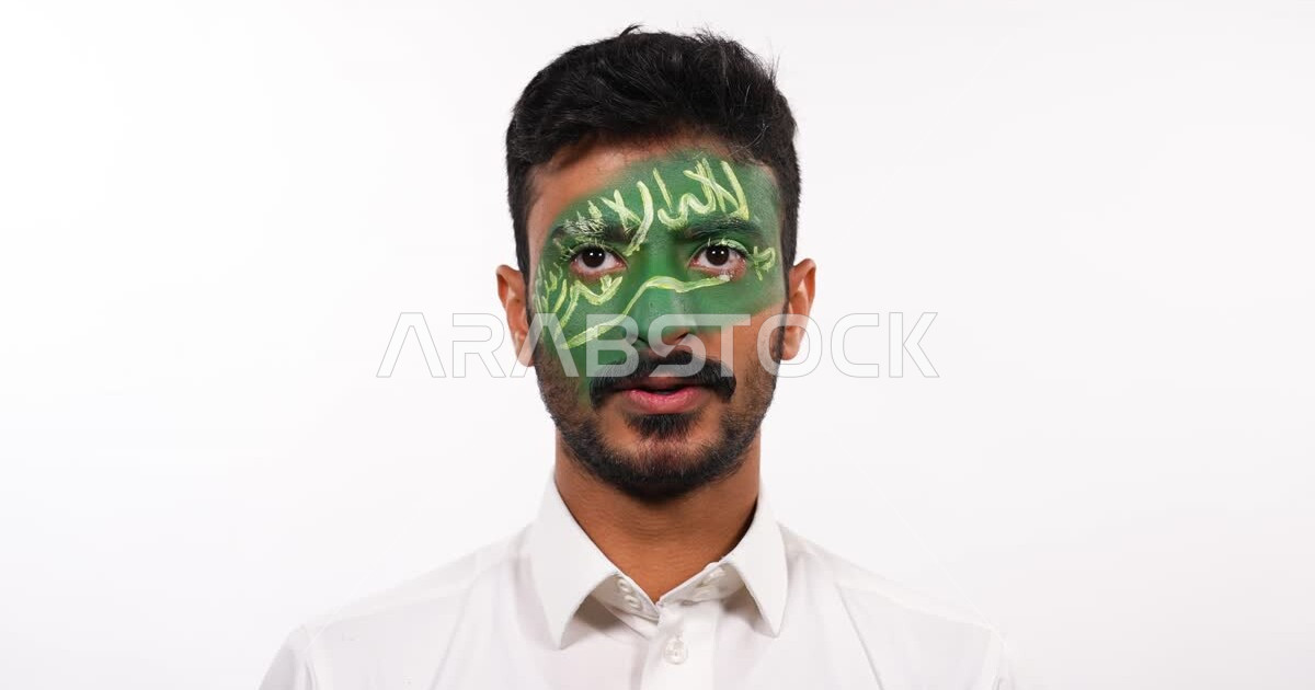 A Gulf Arab youth draws the Saudi flag on his face, encouraging the ...