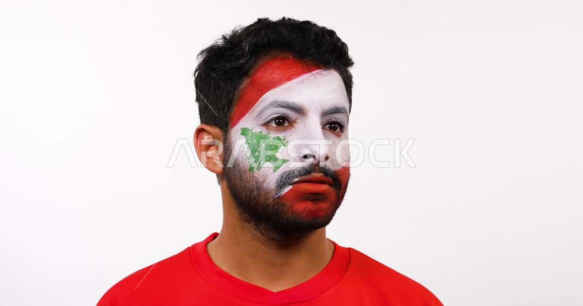 A young Arab man from the Gulf draws the Lebanese flag on his face ...