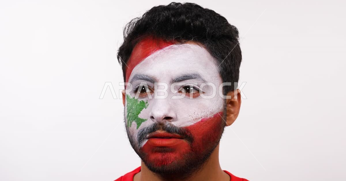 A young Arab man from the Gulf draws the Lebanese flag on his face ...