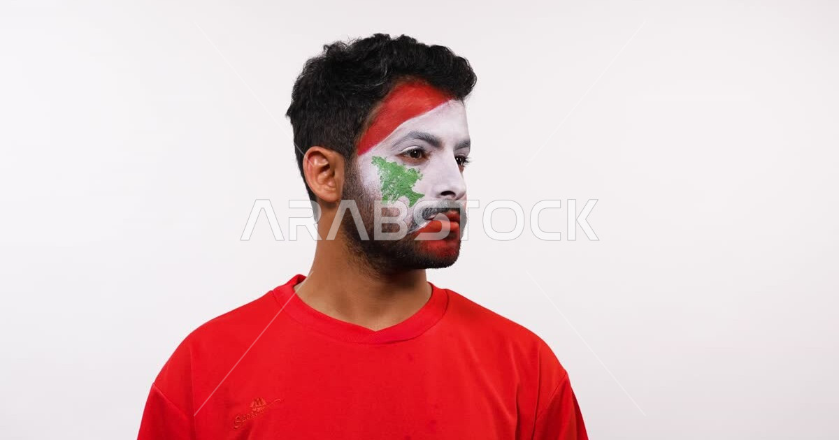 A young Arab man from the Gulf draws the Lebanese flag on his face ...