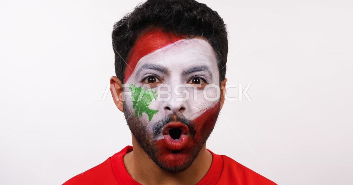 A young Arab man from the Gulf draws the Lebanese flag on his face ...