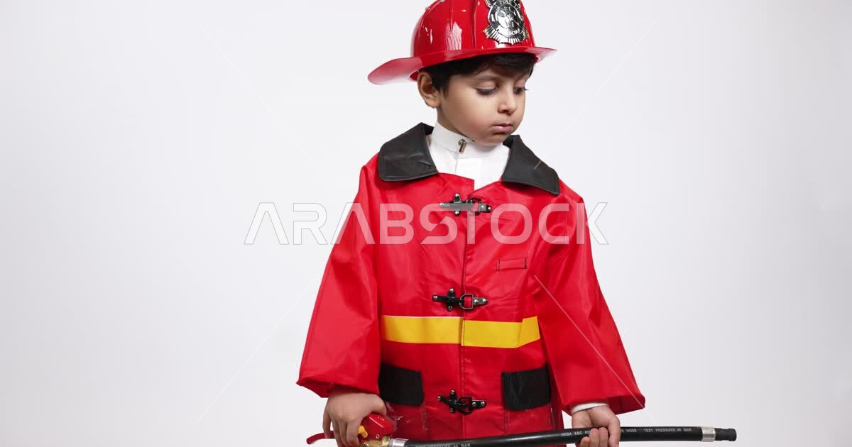 Portrait of a stylish Saudi Arabian Gulf boy, dressed as a firefighter ...