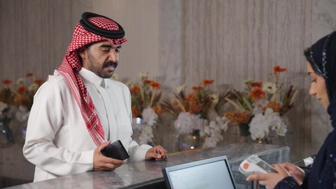 Booking and check-in procedures at the hotel reception desk. A Saudi ...