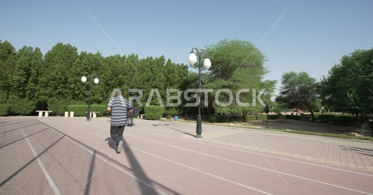 An old Saudi Arabian Gulf man practicing jogging in the garden, a great ...