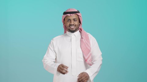 A portrait of a young Arab Gulf Saudi man wearing traditional attire ...