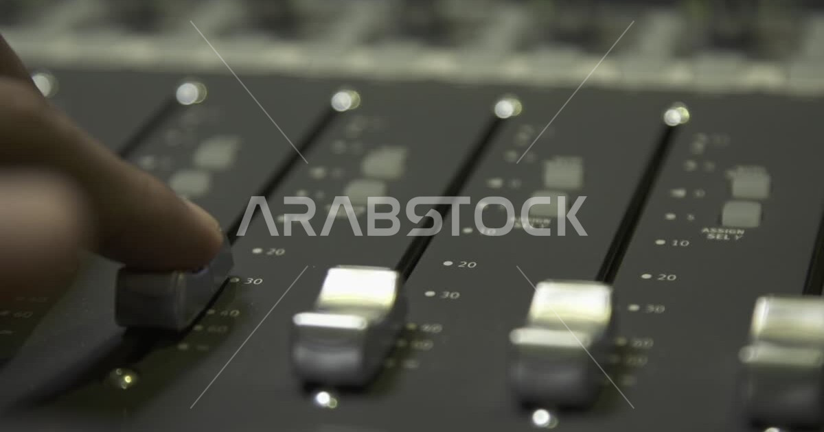 Hand photography of a man adjusting the volume on a console operation ...