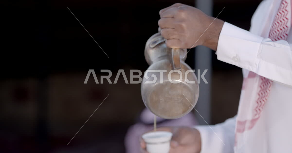 Close-up depiction of a Saudi Arabian Gulf man holding a jug in his ...