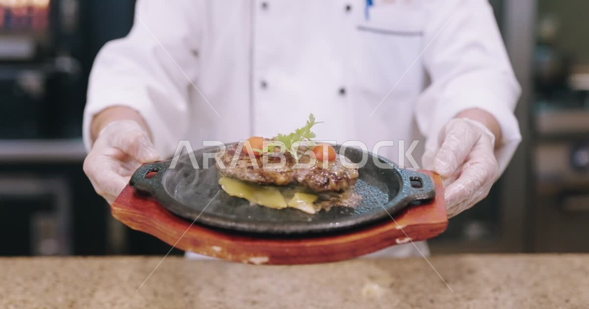 A Saudi Arabian Gulf cook prepares food to be served in the restaurant ...