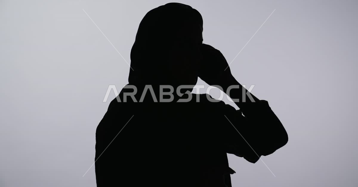 The shadow of a Saudi Arabian Gulf woman with a mobile phone in her ...