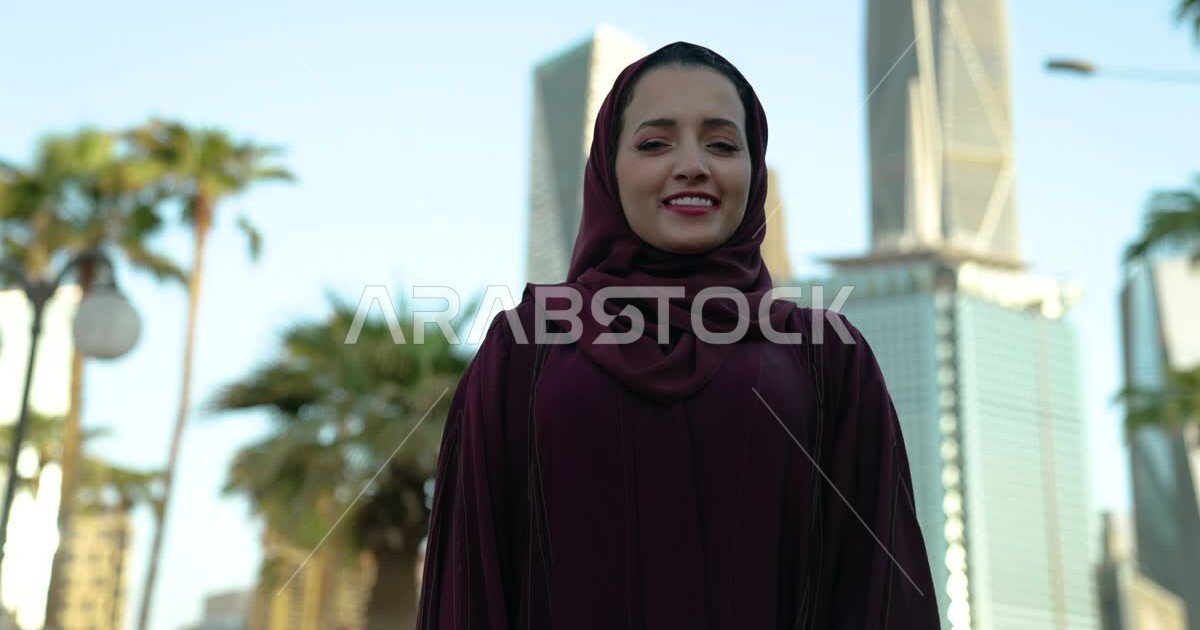 A Saudi Arabian Gulf woman standing in front of the towers of King ...