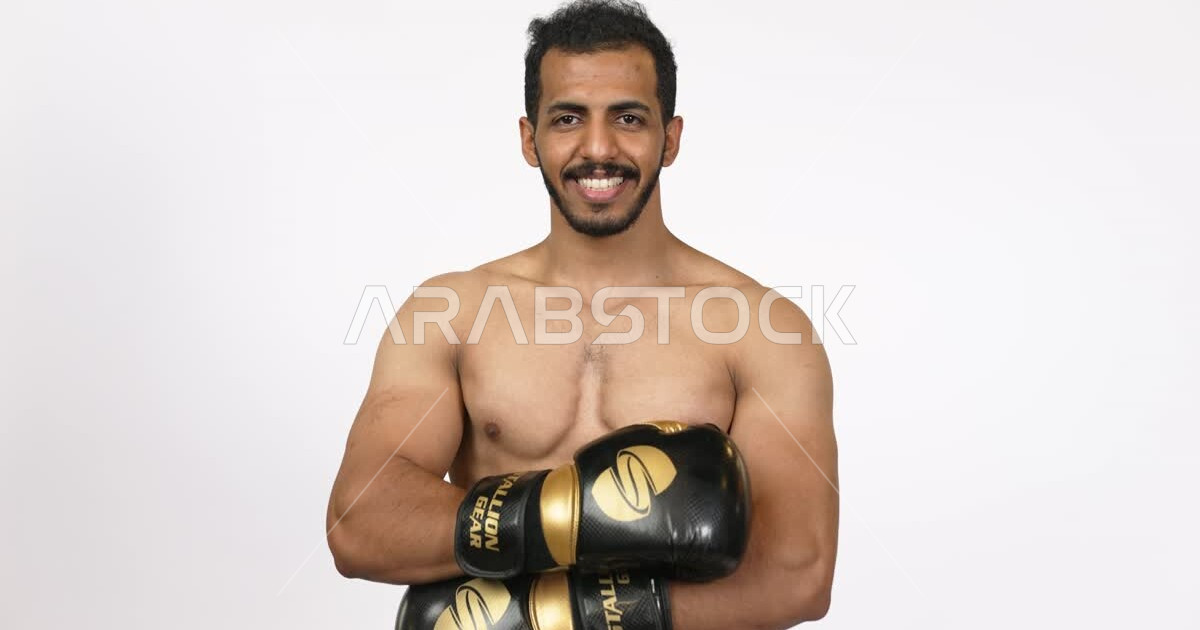 Portrait of a Saudi Arabian Gulf Arab man boxer wearing boxing gloves ...