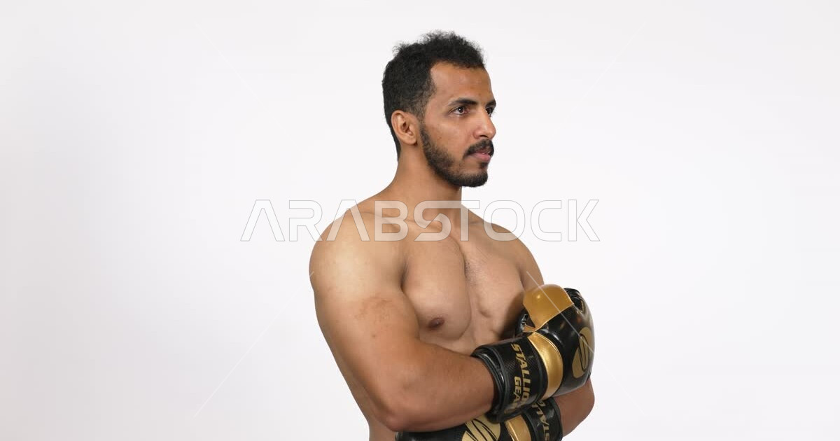 Portrait of a Saudi Arabian Gulf Arab man boxer wearing boxing gloves ...