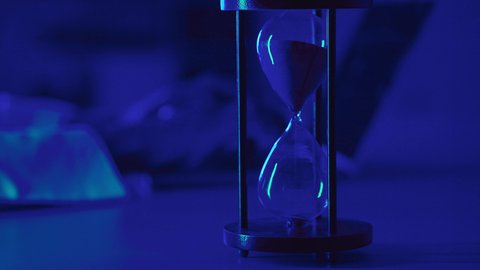 Using an hourglass to set a work schedule, a close-up shot of a young ...