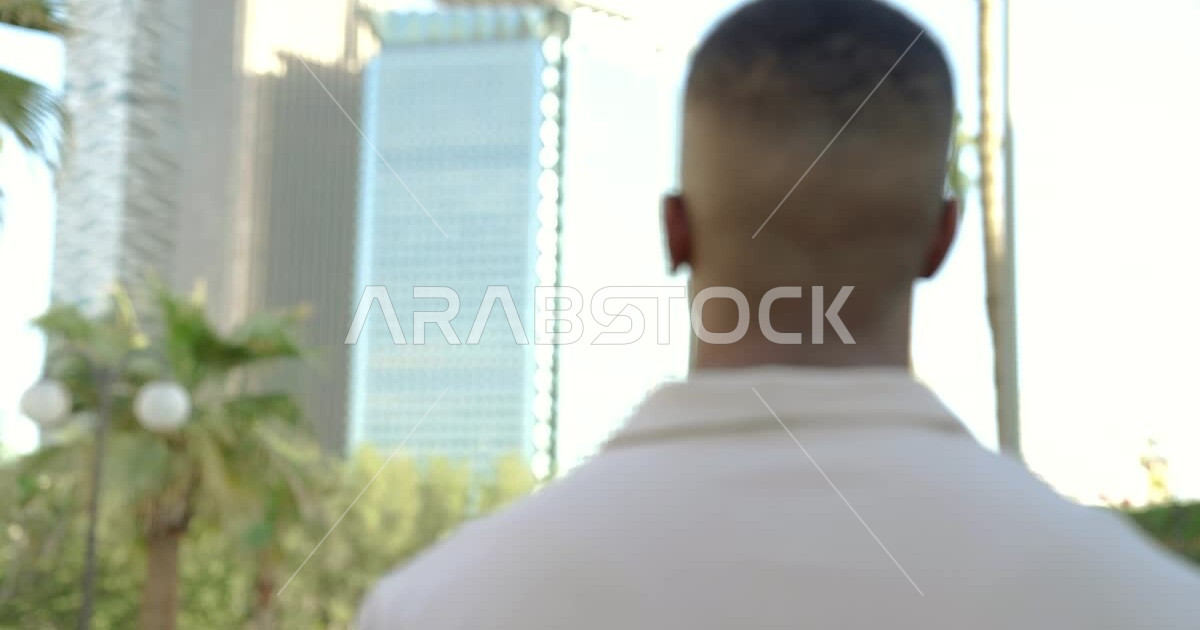 Photography from the back of a dark-skinned Saudi Arabian Gulf Arab man ...