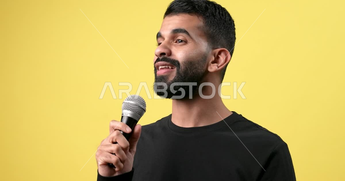 Portrait of a Saudi Arabian Gulf man holding the microphone and singing ...