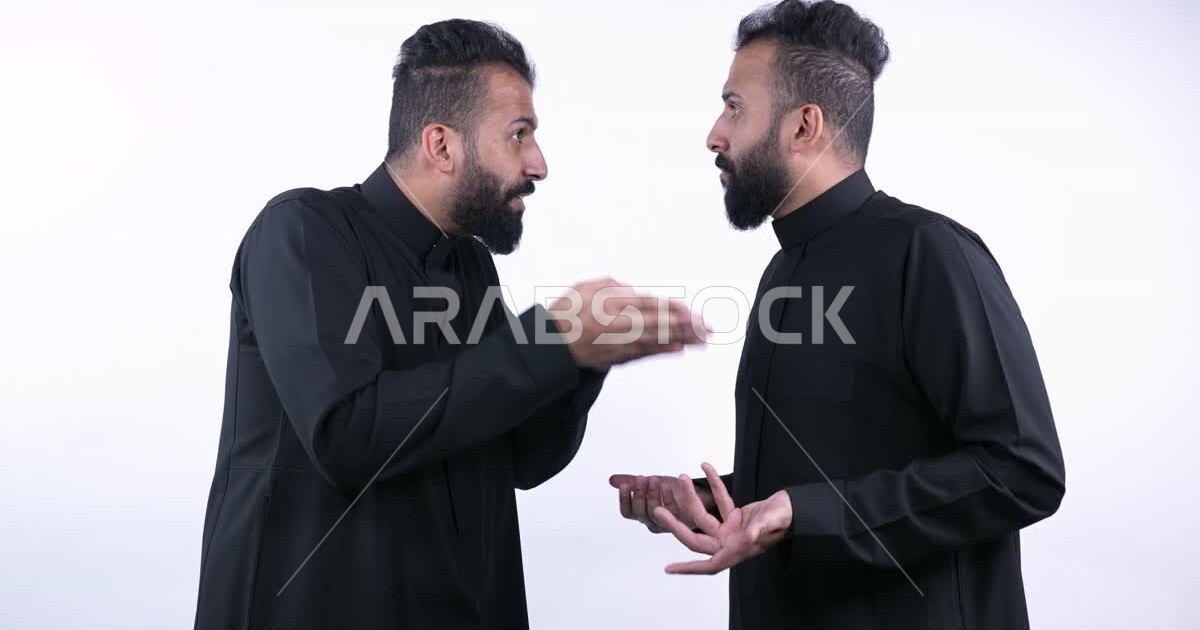 Portrait of two Saudi Arabian Gulf twin men standing opposite each ...