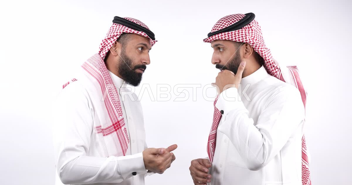 Portrait of two Saudi Arabian Gulf Arab twin men discussing something ...