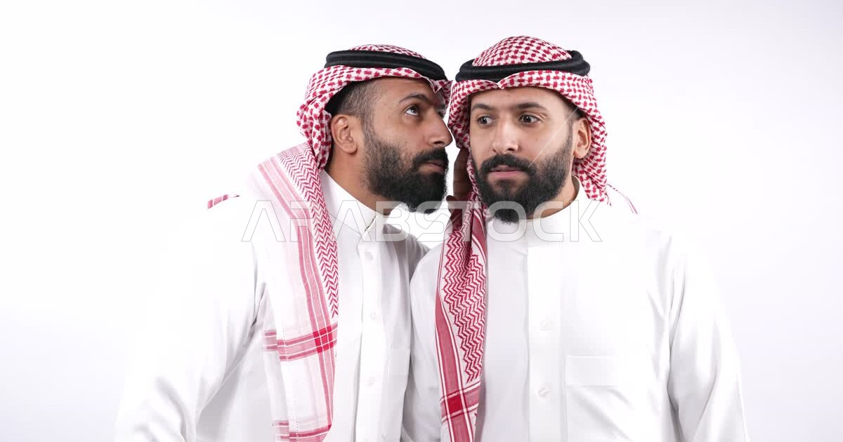 Portrait of two Saudi Arabian Gulf twins, a brother whispering in the ...