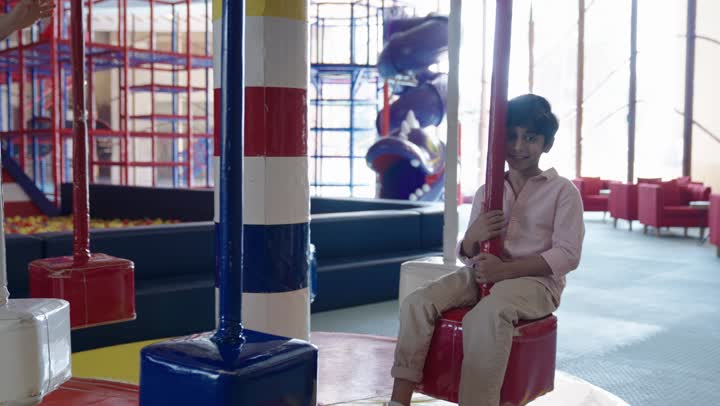 A small Arab Saudi Gulf child wearing casual attire looks happily at ...