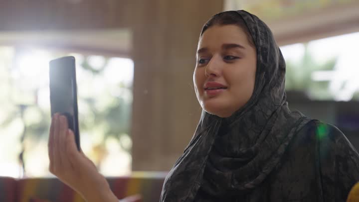 A small Arab Saudi Gulf child wearing casual attire looks happily at ...