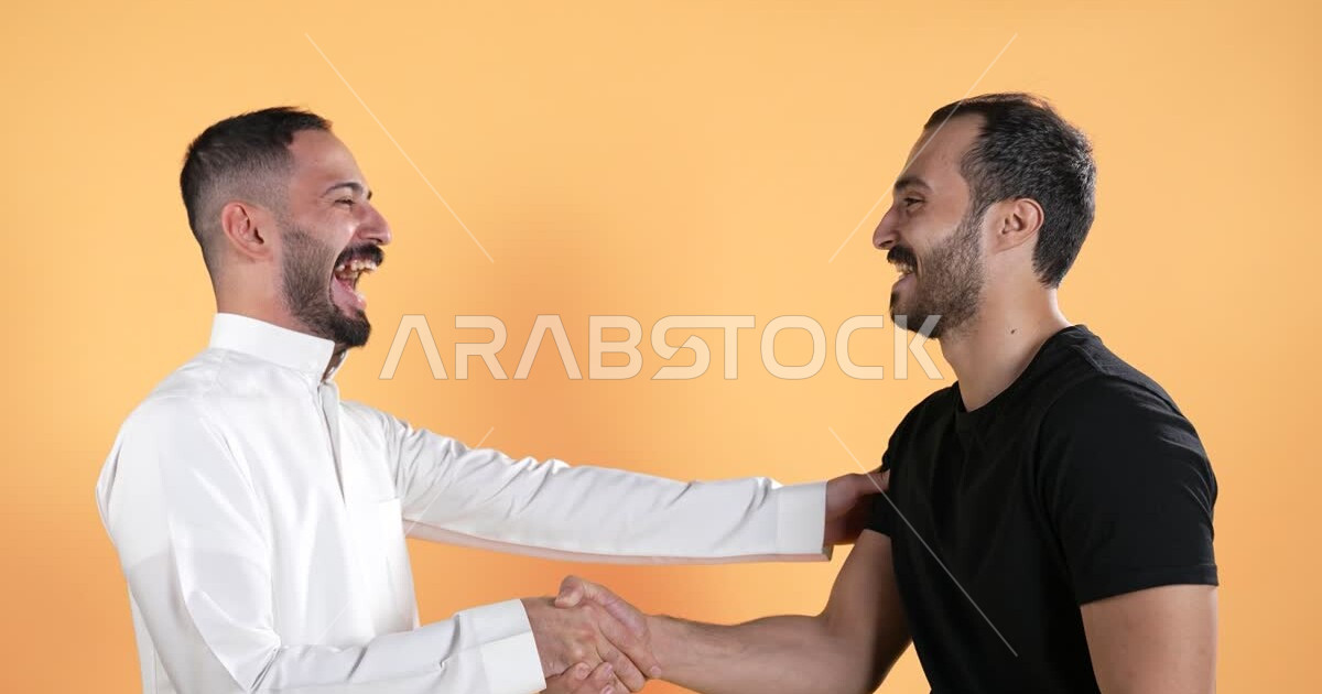 Two Gulf Arab Saudi men shake hands with each other, friendship and ...