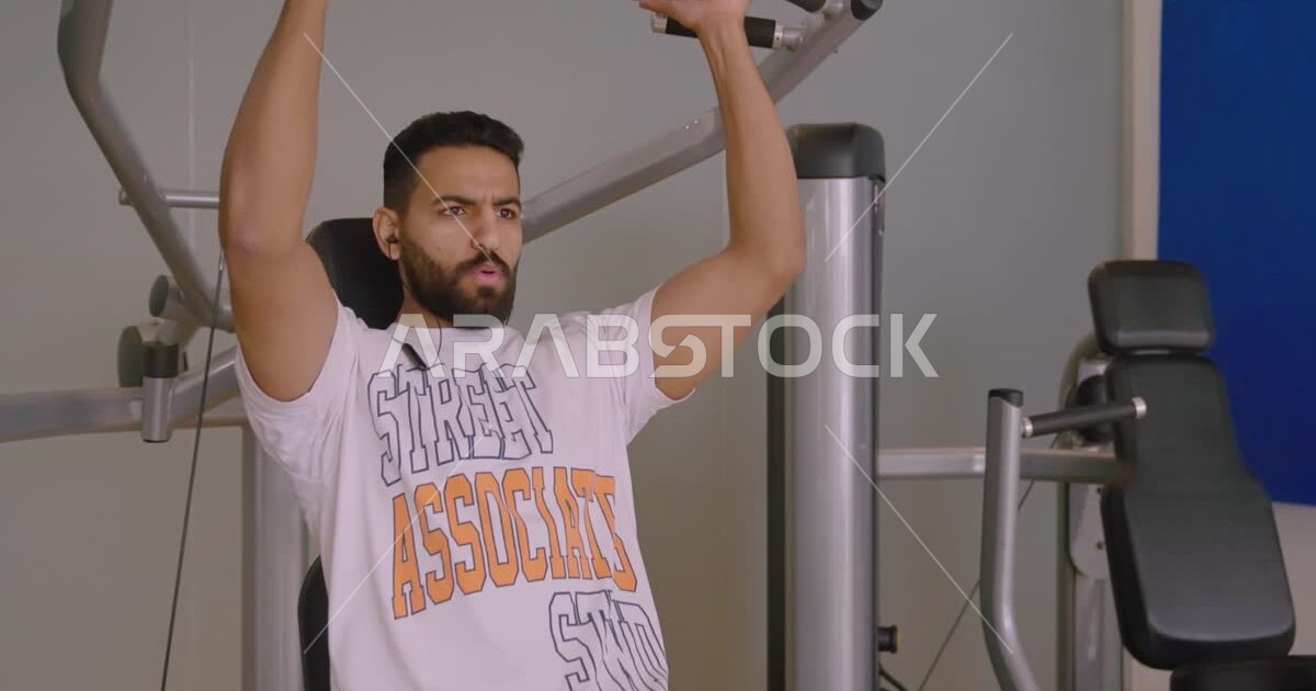 A Saudi Arabian Gulf man wears sports clothes and exercises using ...