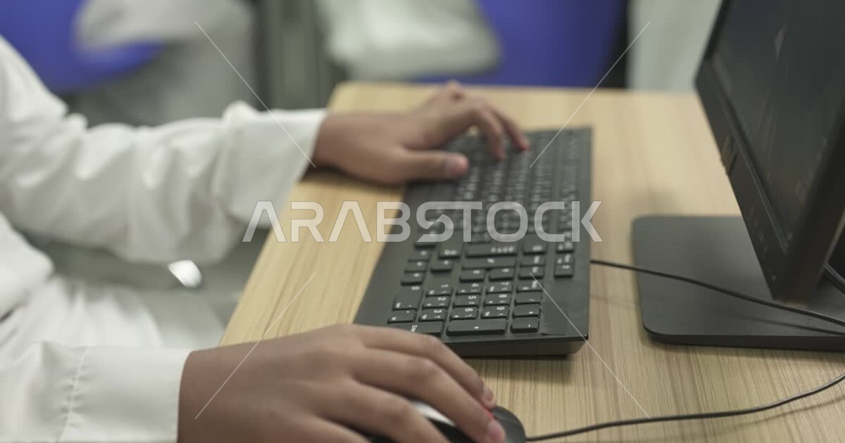 A Saudi Arabian Gulf teacher in the computer lab, teaching students how ...