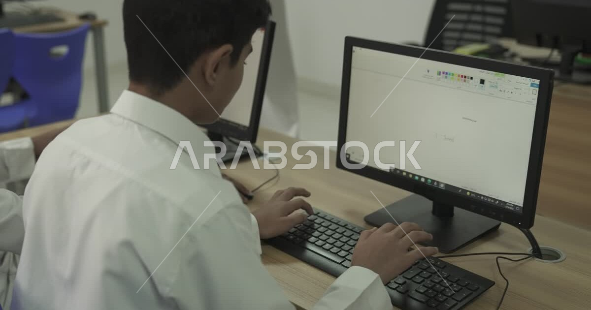 A Saudi Arabian Gulf teacher in the computer lab, teaching students how ...