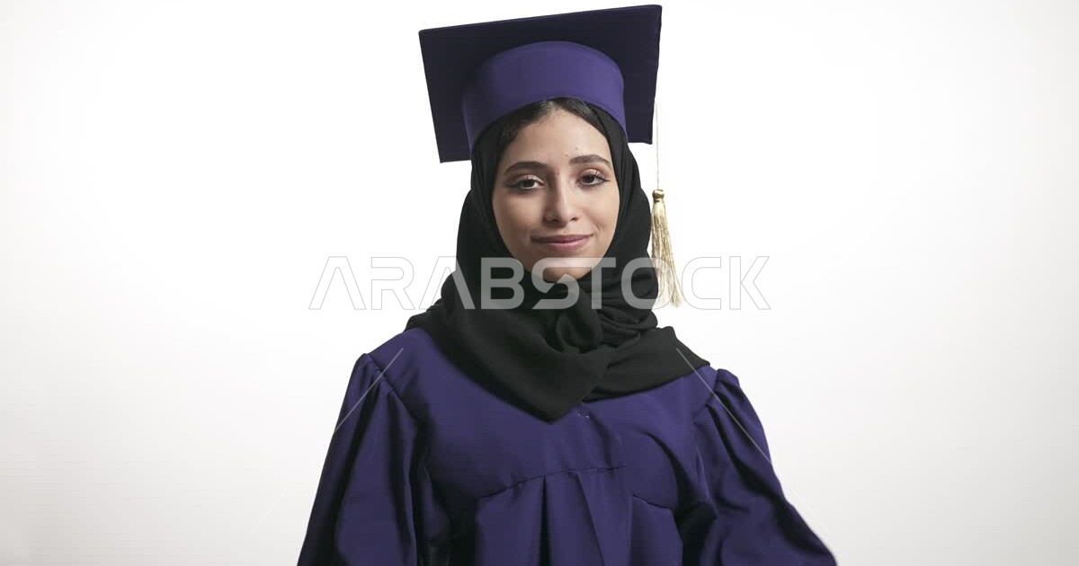 Portrait of a veiled Saudi Arabian Gulf student wearing graduation gown ...