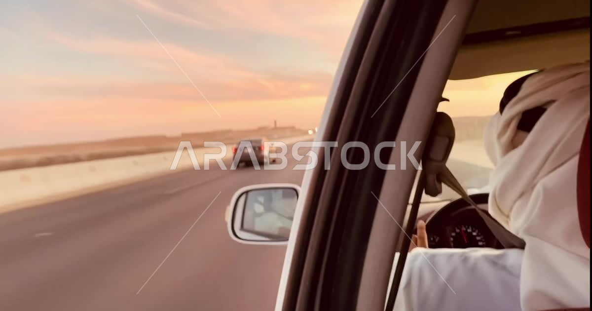 Angle from the back of a Gulf Arab man driving the car on the highway ...