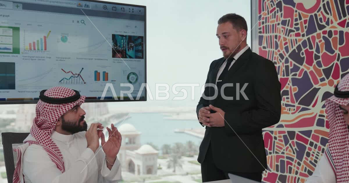A Saudi work team and a man in a uniform study and analyze project ...