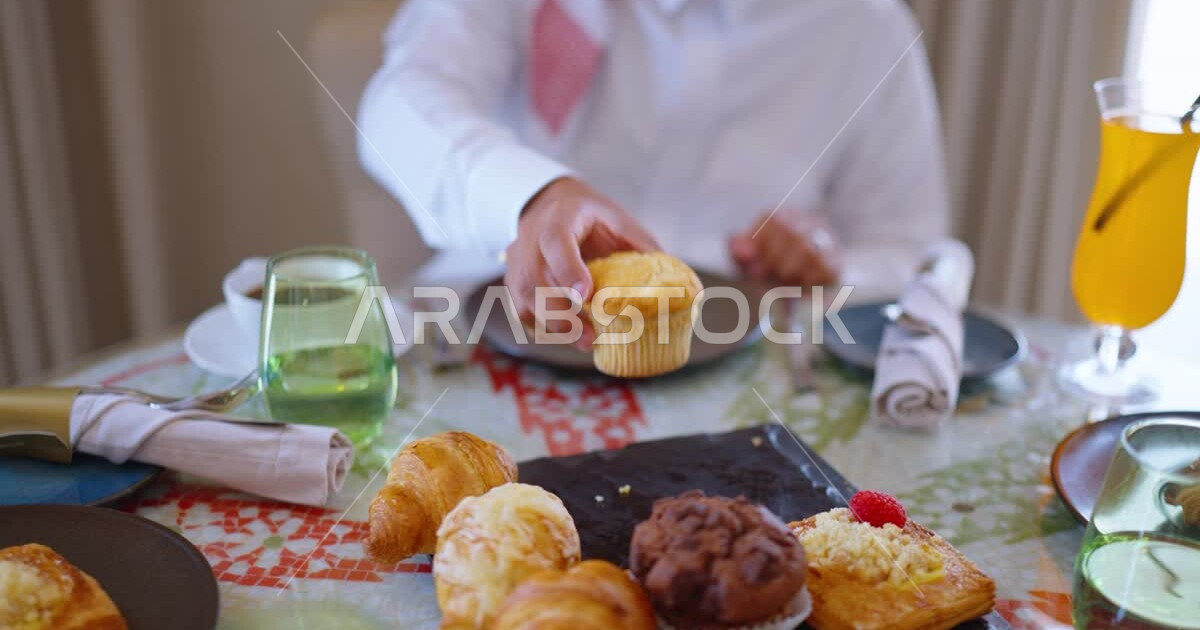 A Saudi Arabian Gulf couple sitting at the dining table in the ...
