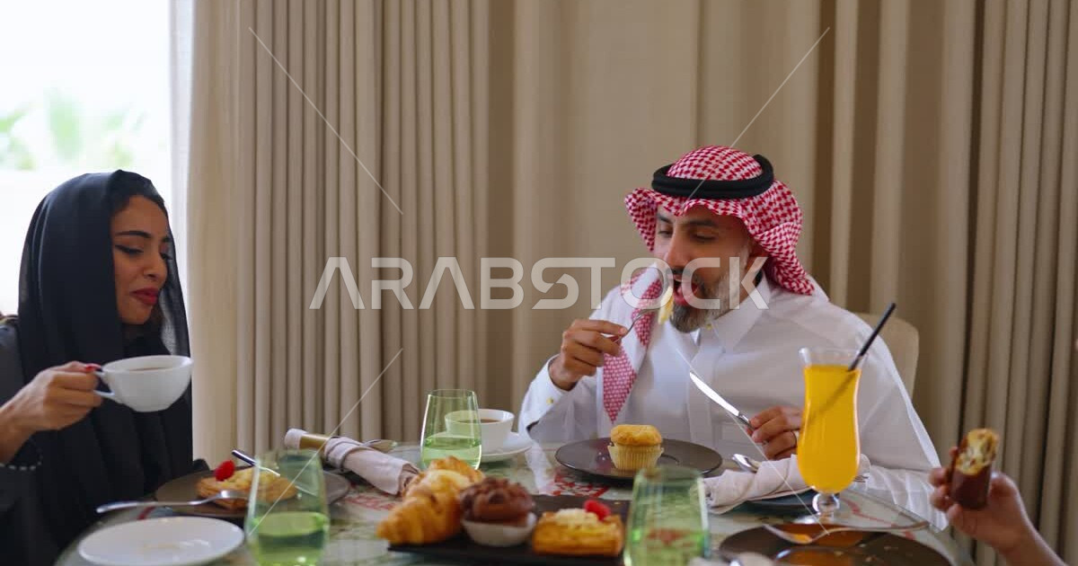 A Saudi Arabian Gulf family sitting at the dining table in the ...