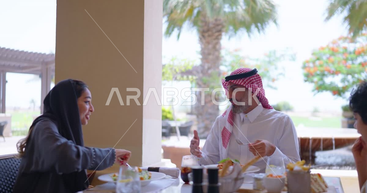 A Saudi Arabian Gulf family sitting at the dining table in the ...