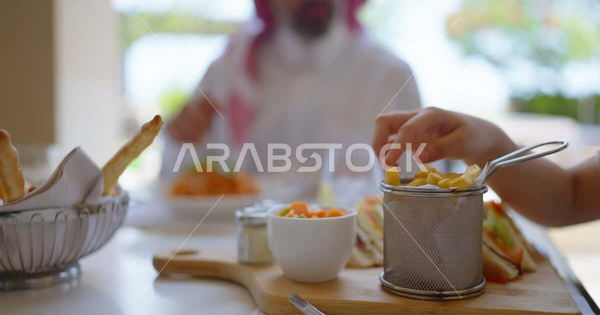 A Saudi Arabian Gulf family sitting at the dining table in the ...