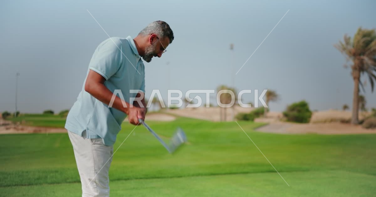 A Saudi Arabian Gulf man wearing a sports uniform, playing golf on ...