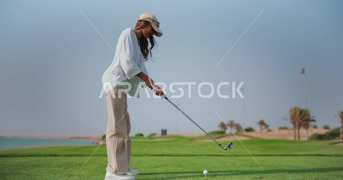 A Saudi Arabian Gulf woman wearing a sports uniform, playing golf on ...