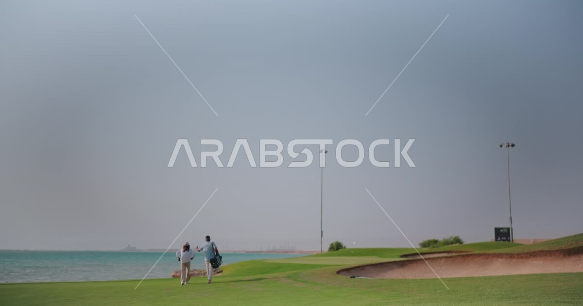 A Saudi Arabian Gulf man and woman wearing sports uniforms, playing ...