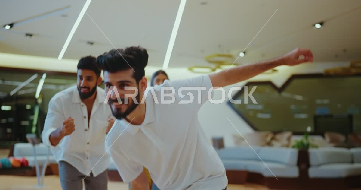 Two Gulf Arab Saudi men and women playing bowling, a bowling track, a ...