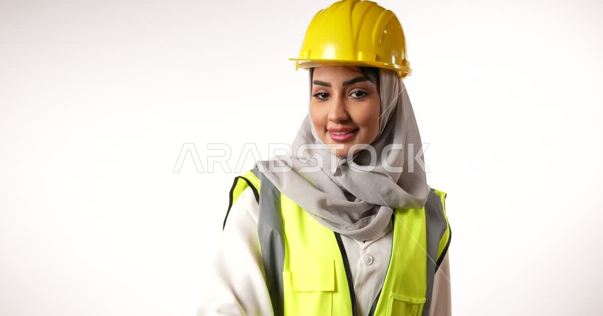Portrait of a veiled Saudi Arabian Gulf engineer, wearing a helmet and ...